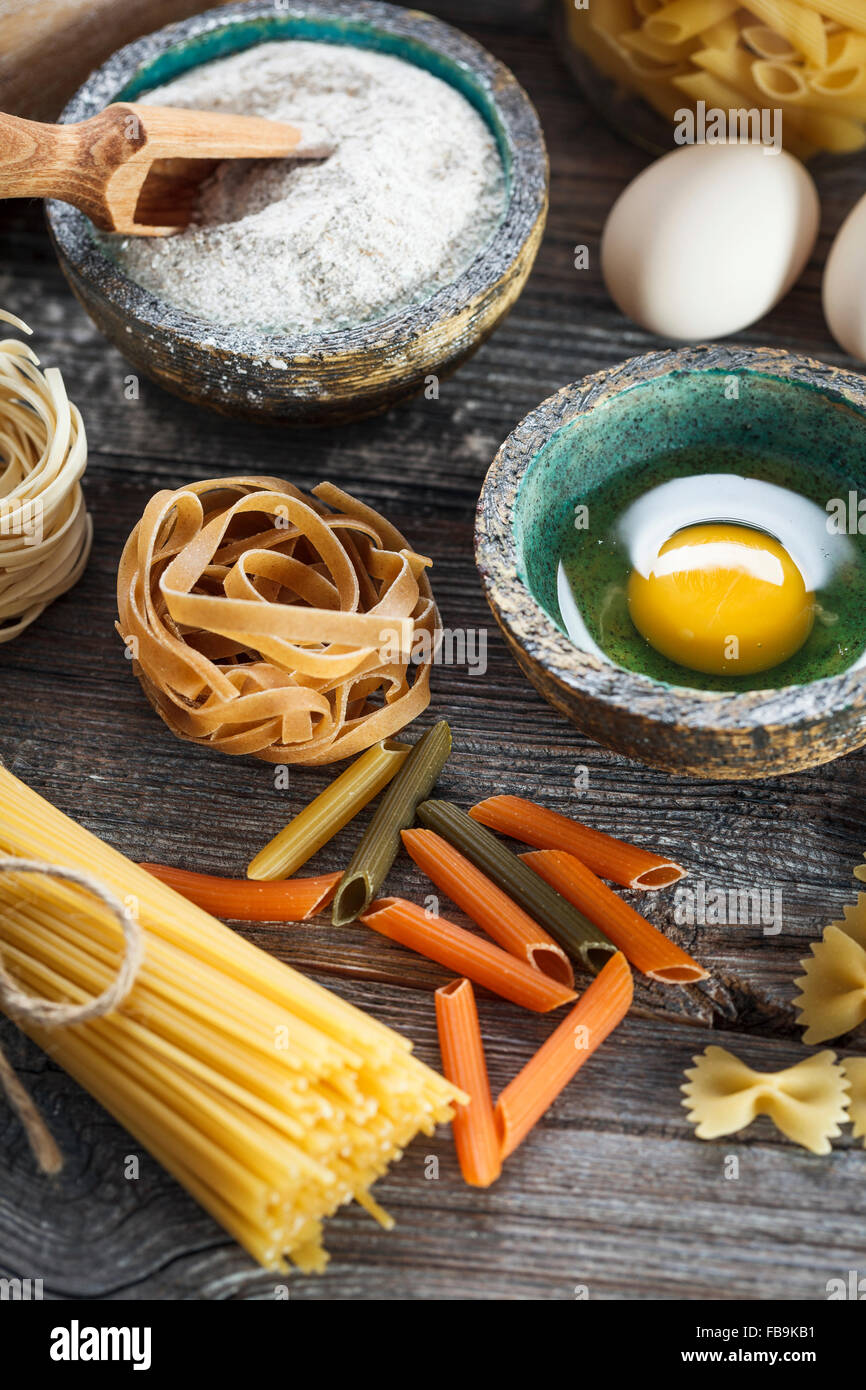 A set of raw pasta and addons on wooden table. Studio picture Stock ...