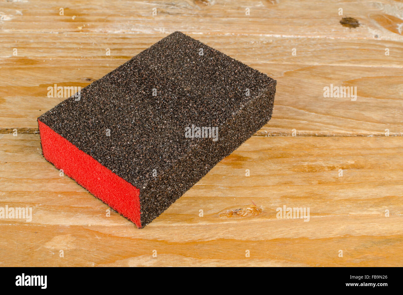 Block of very coarse sand paper on a wooden surface Stock Photo - Alamy