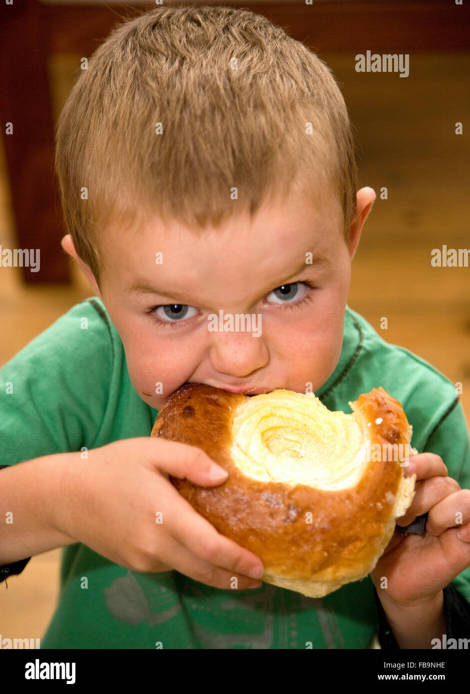 Child young boy eating bakery sweet buns Stock Photo - Alamy