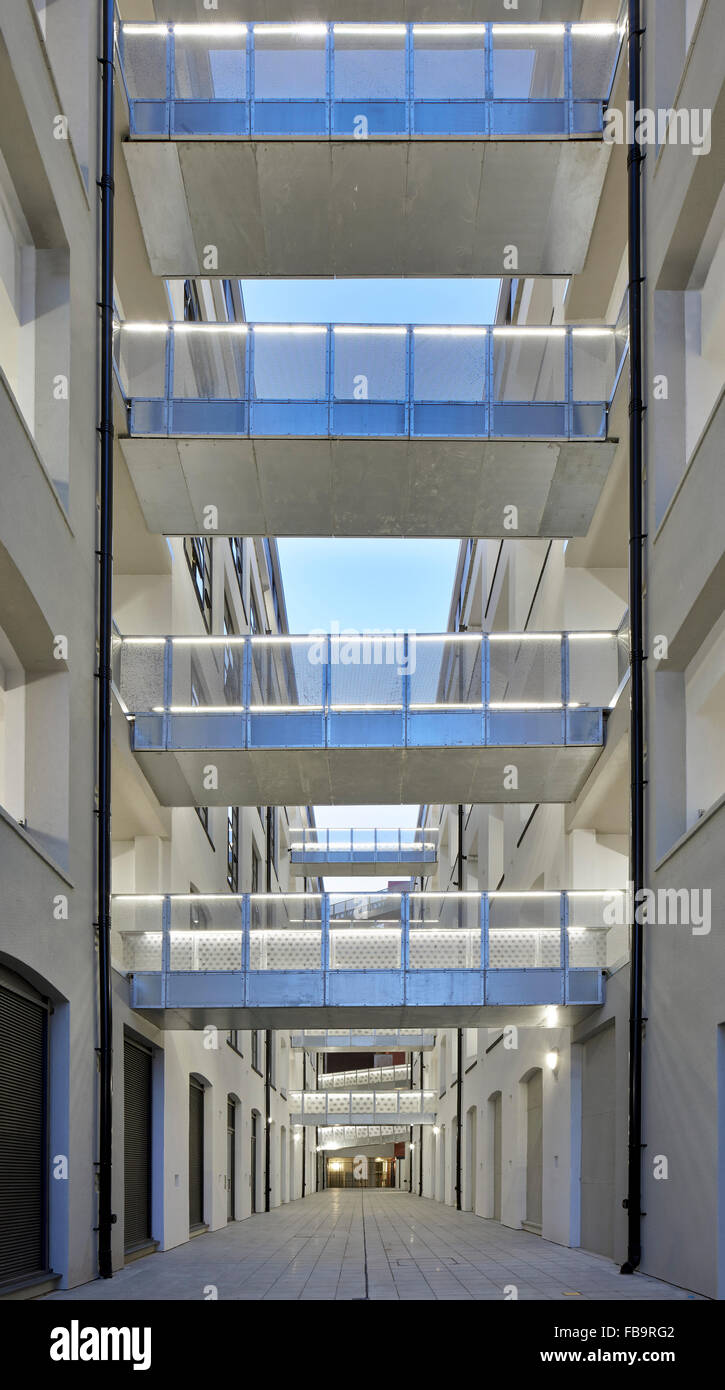 Ground level view of building's internal street at dusk. The Textile ...