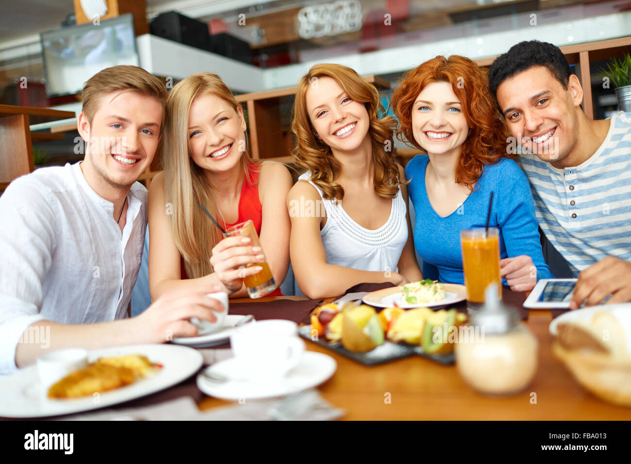 Portrait of happy friends having lunch together in cafe Stock Photo - Alamy