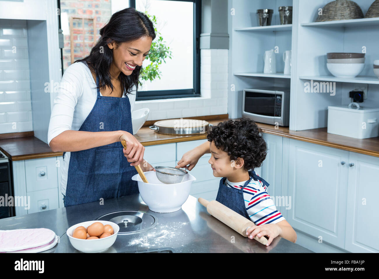 Smiling mother cooking with her son Stock Photo - Alamy