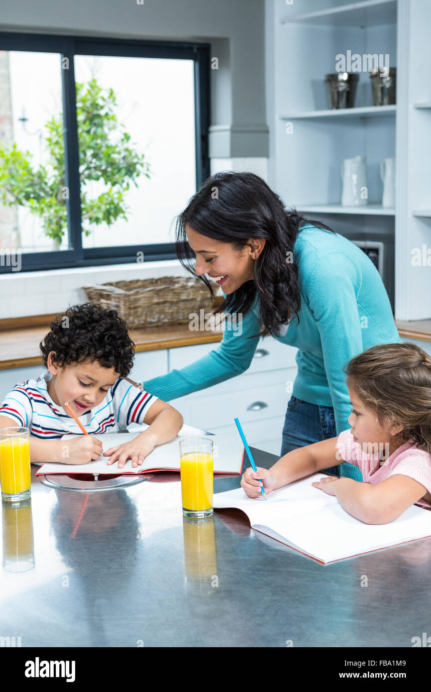 Kind mother helping her children doing homework Stock Photo - Alamy