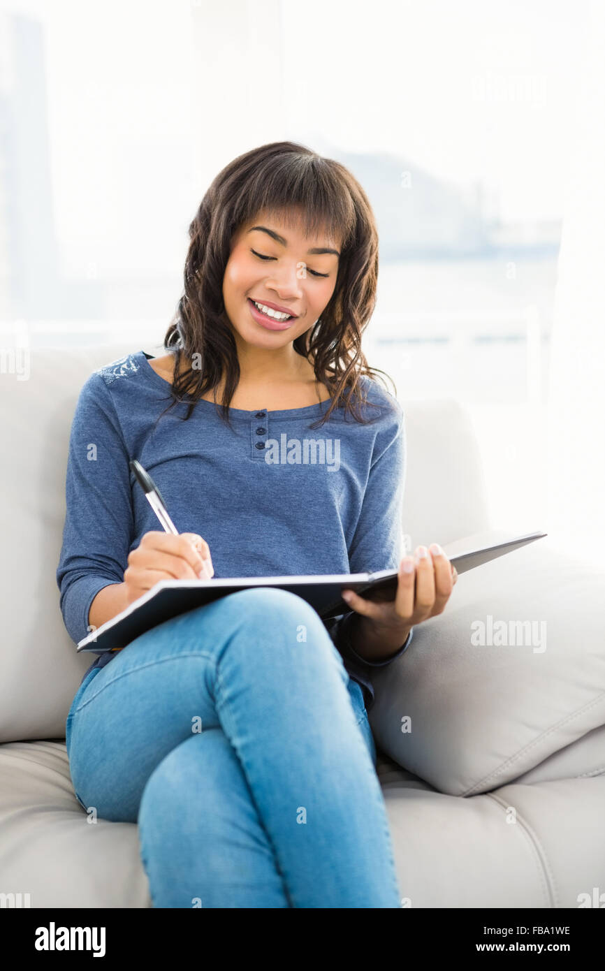Smiling casual woman writing notes Stock Photo - Alamy