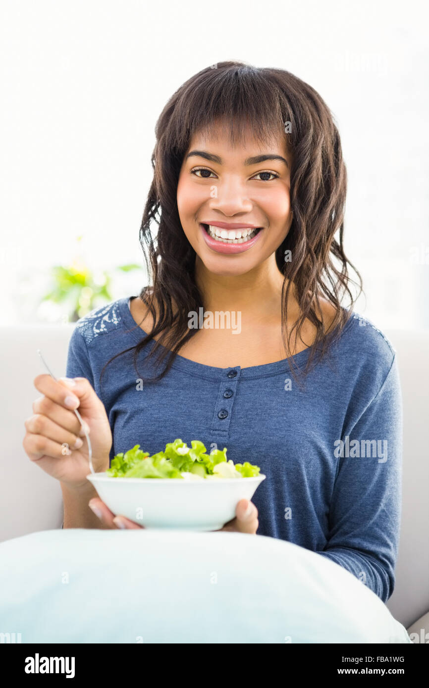 Casual smiling woman eating salad Stock Photo - Alamy