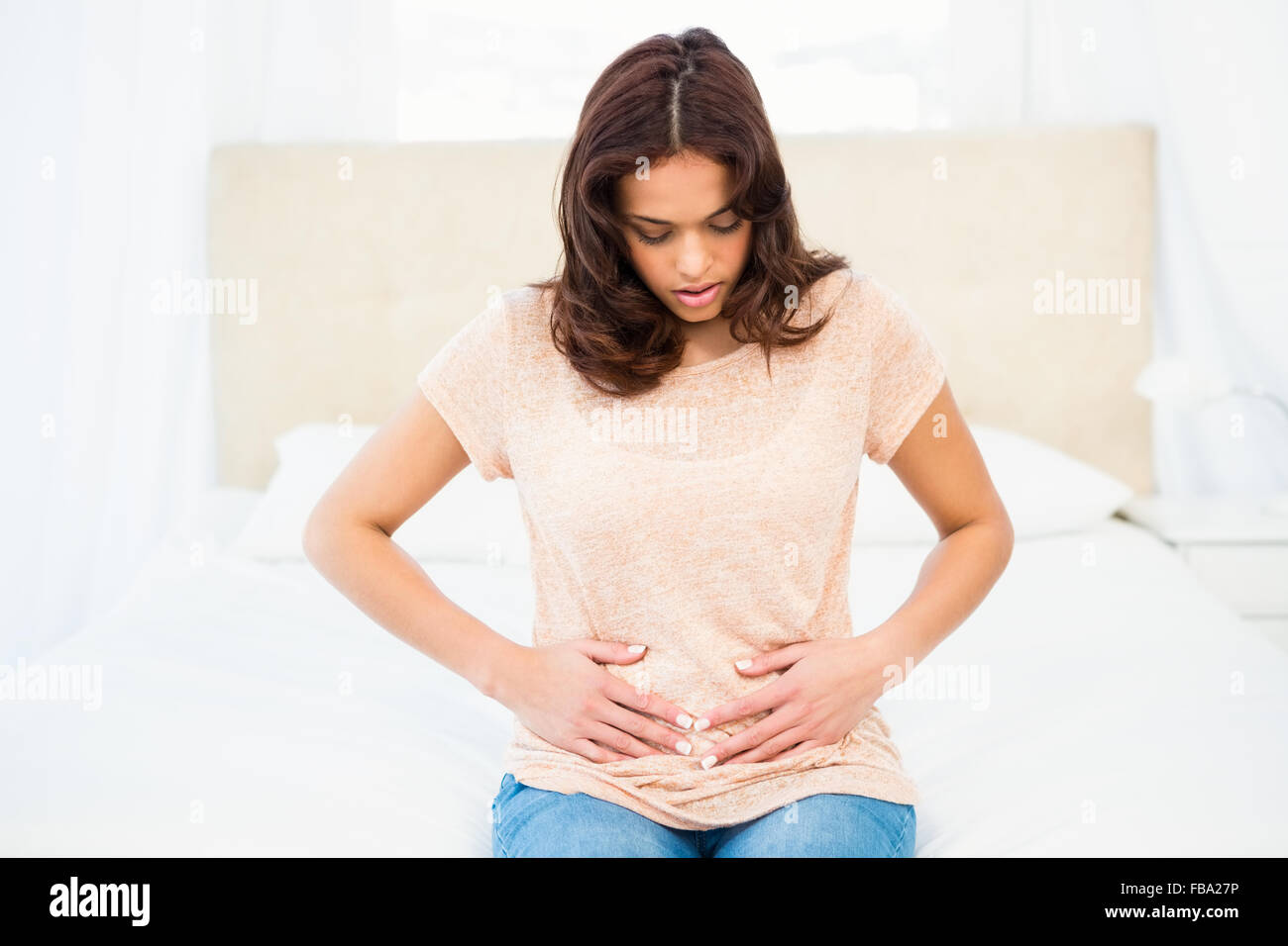 Casual smiling woman touching her belly Stock Photo - Alamy