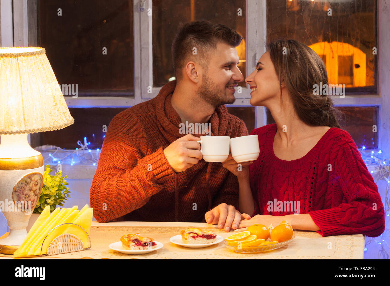 The happy young couple with cups of tea Stock Photo - Alamy