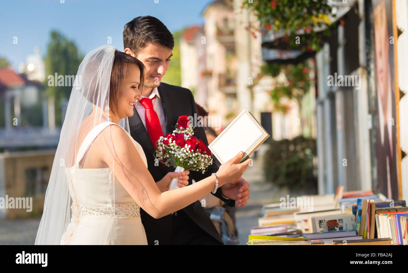 Beautiful wedding couple reviewing vintage books Stock Photo - Alamy