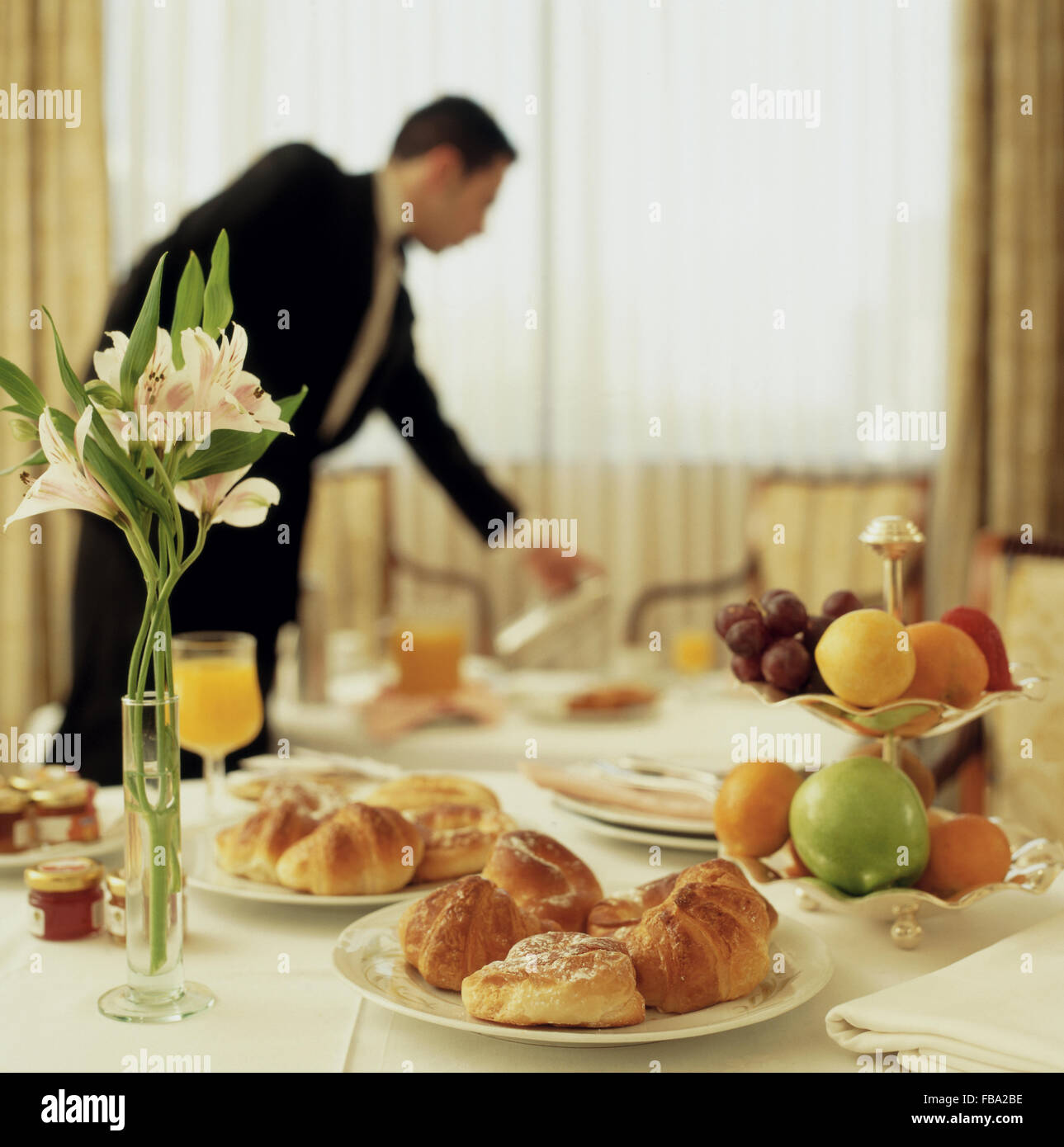 Big Hotel room service continental breakfast with waitress out of focus ...
