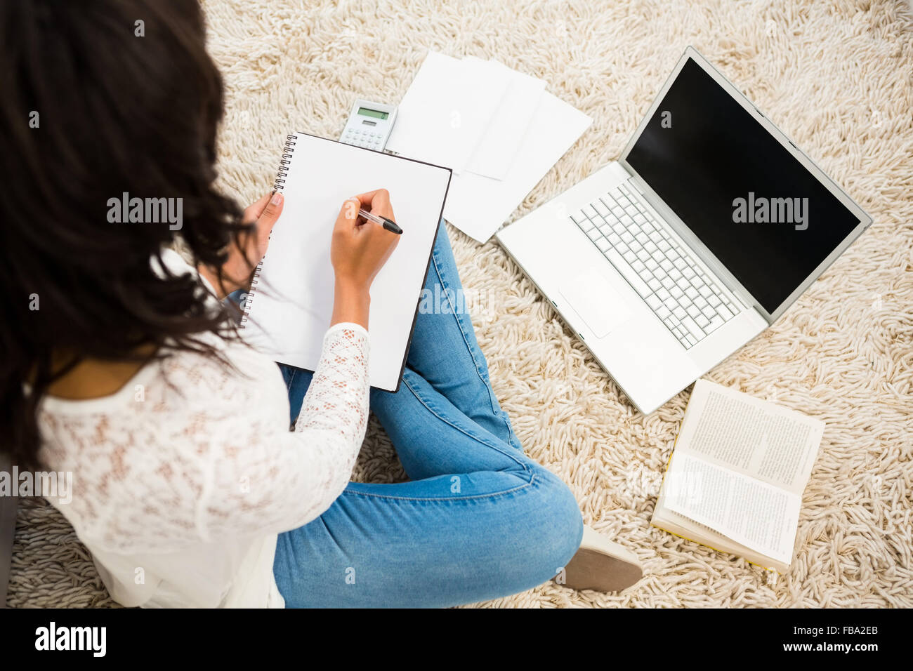 Above view of a woman writing note while using her laptop Stock Photo ...