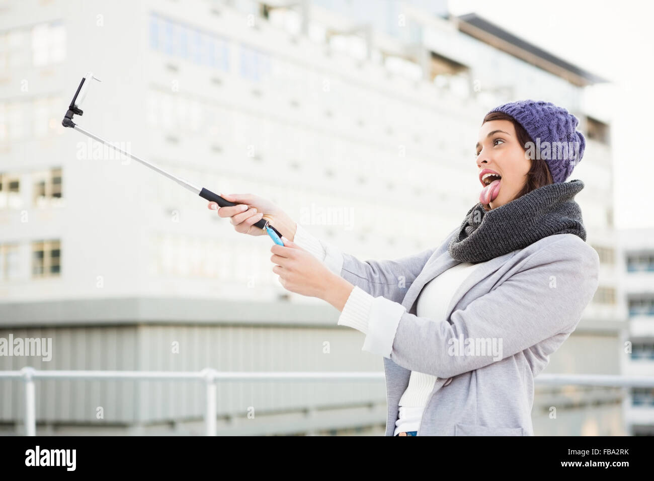 Happy woman using selfie stick Stock Photo - Alamy
