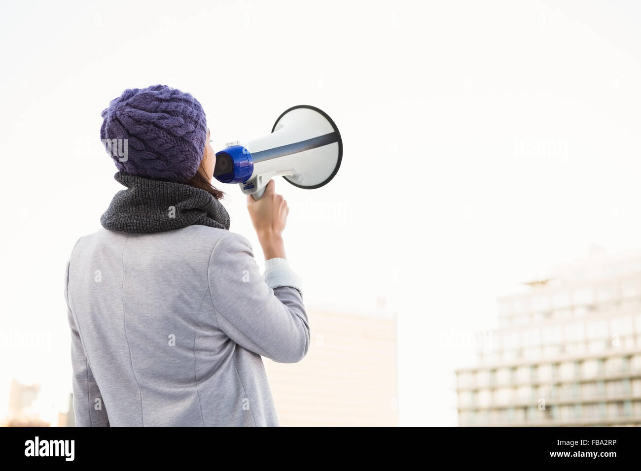 Rear view of woman shouting with megaphone Stock Photo - Alamy
