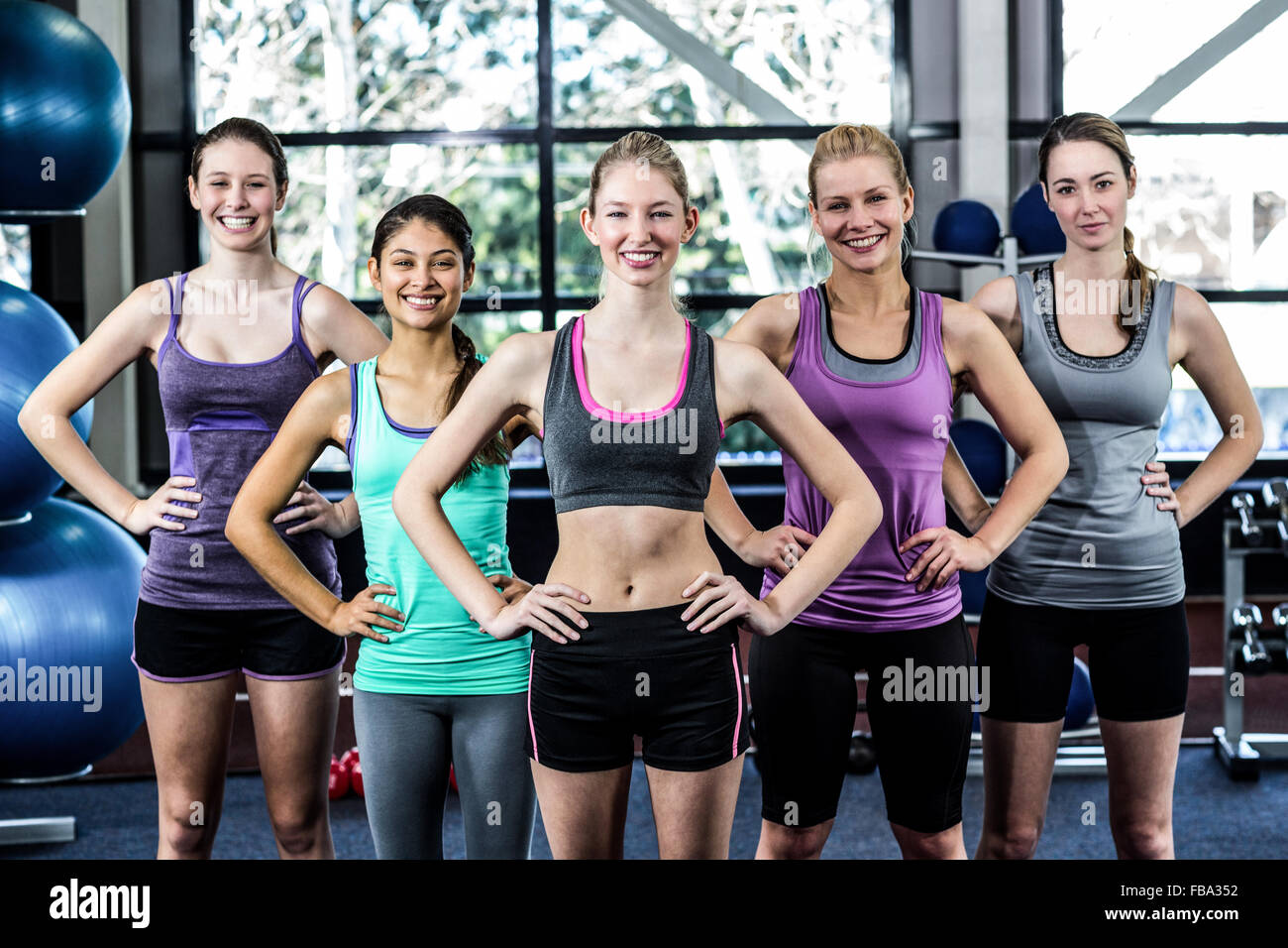 Smiling women posing together with hands on hips Stock Photo - Alamy