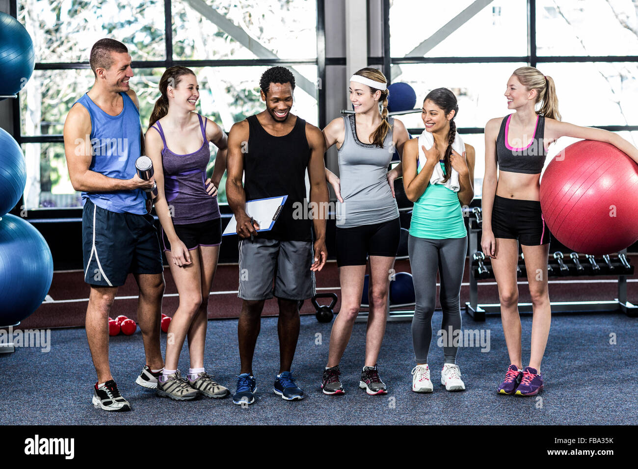Smiling fitness class posing together Stock Photo - Alamy