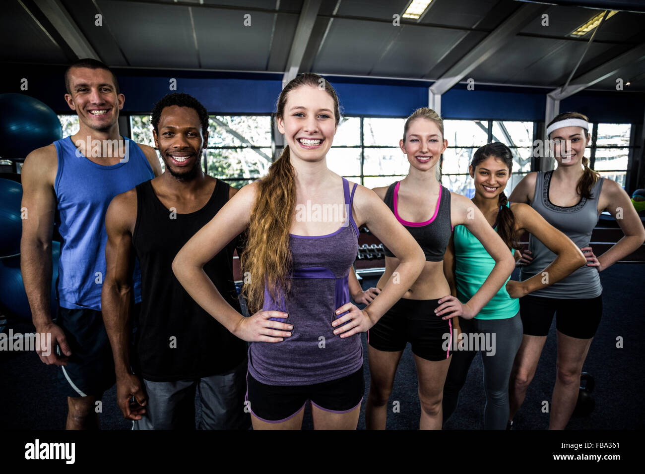 Smiling fitness class posing together with hands on hips Stock Photo ...
