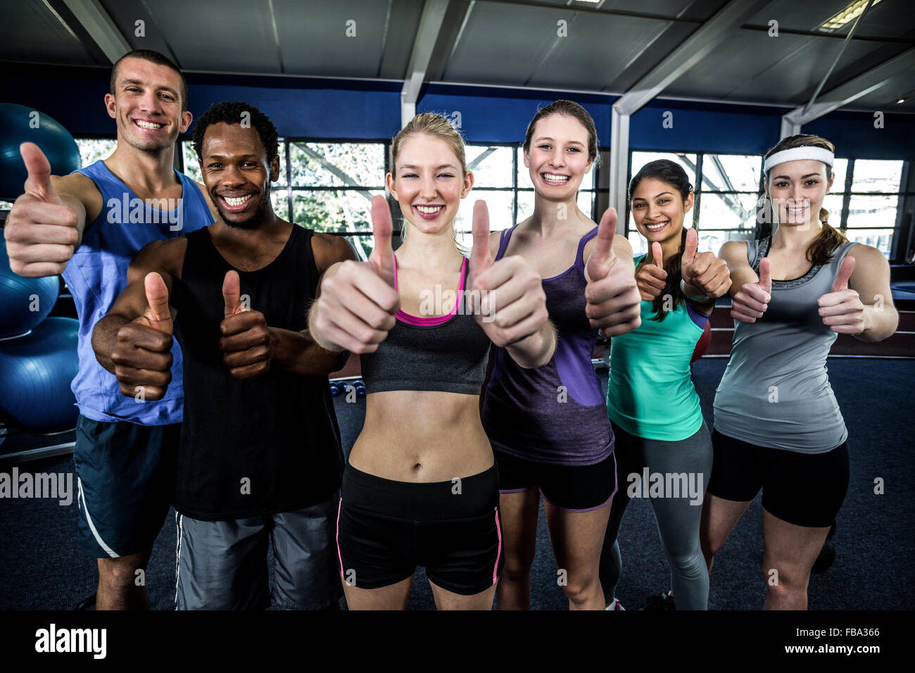 Smiling fitness class posing together Stock Photo - Alamy