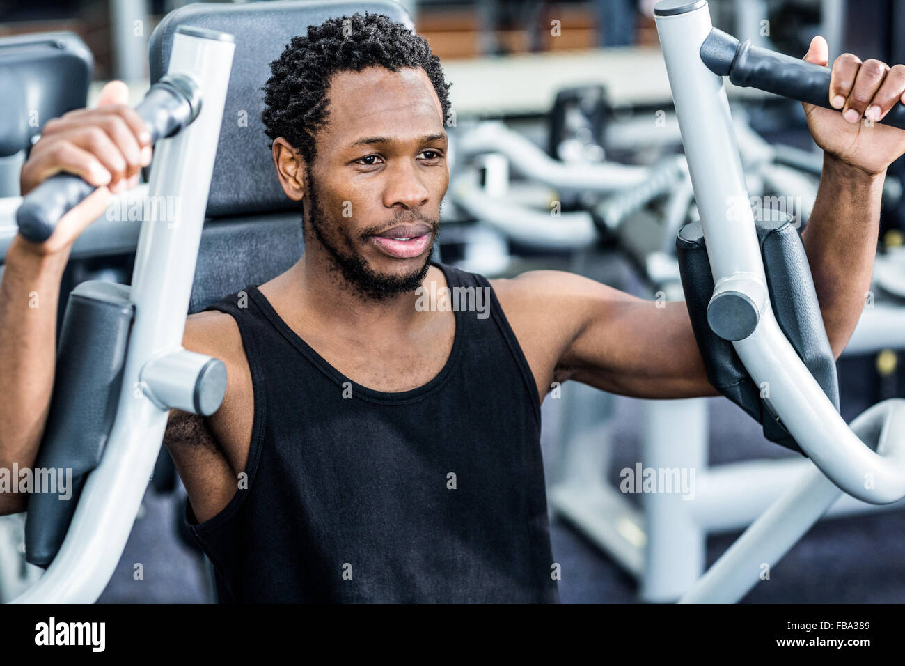 Fit man using exercise machine Stock Photo - Alamy