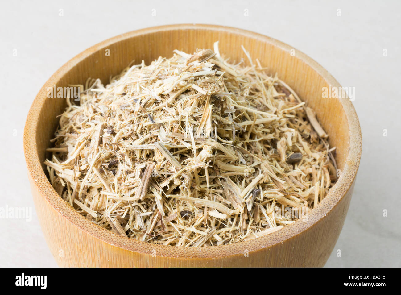Chopped Nettle root "Urtica dioica" in a wooden cup Stock Photo - Alamy