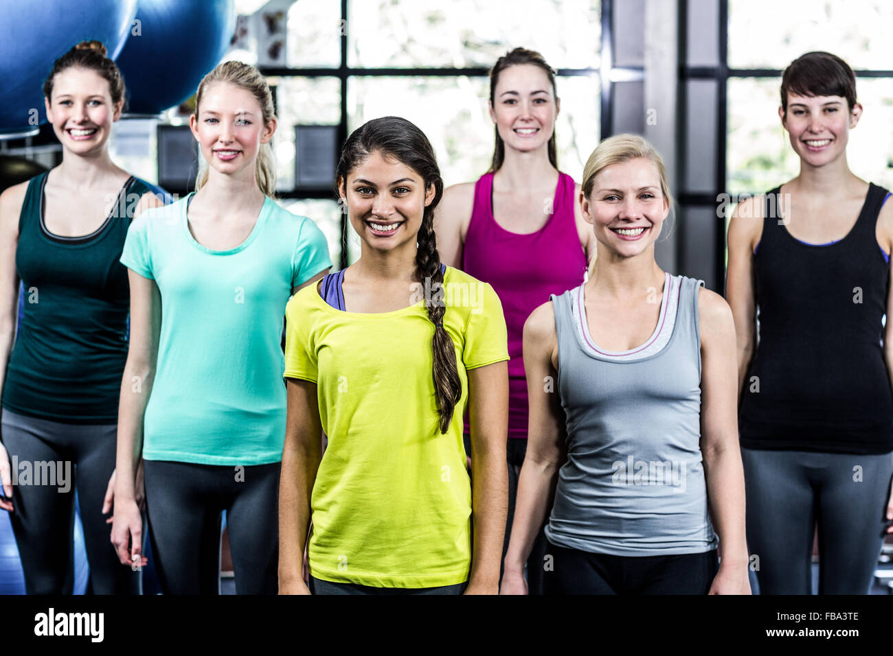 Fit smiling group standing straight Stock Photo - Alamy