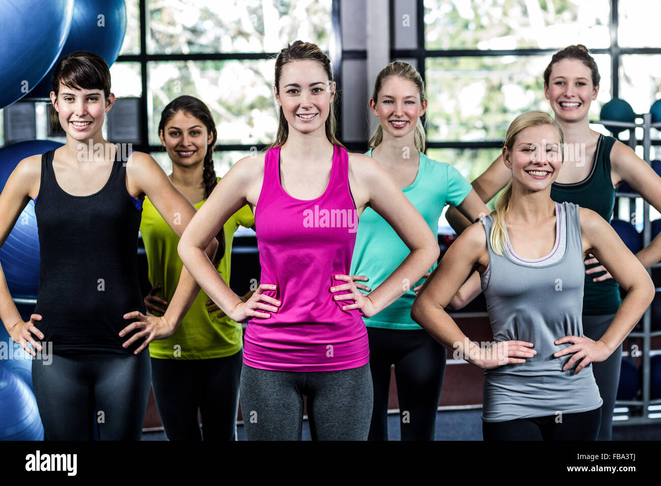 Fit smiling group with hands on hips Stock Photo - Alamy