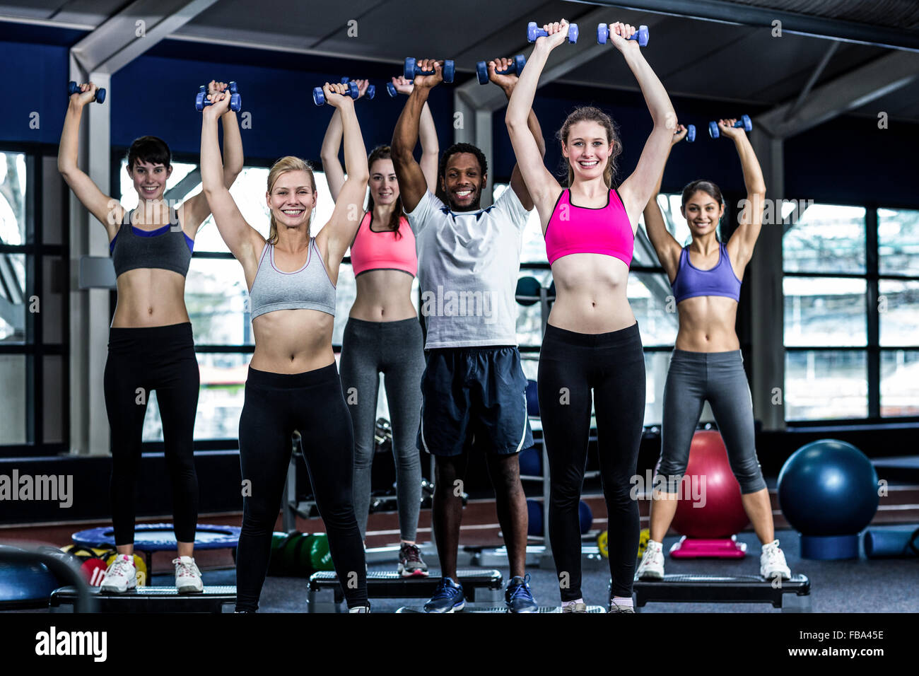 Fit smiling group doing exercise Stock Photo - Alamy