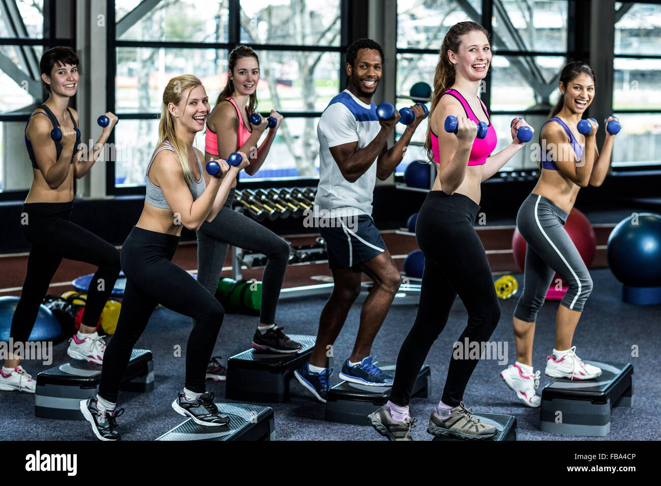 Fit smiling group doing exercise Stock Photo - Alamy