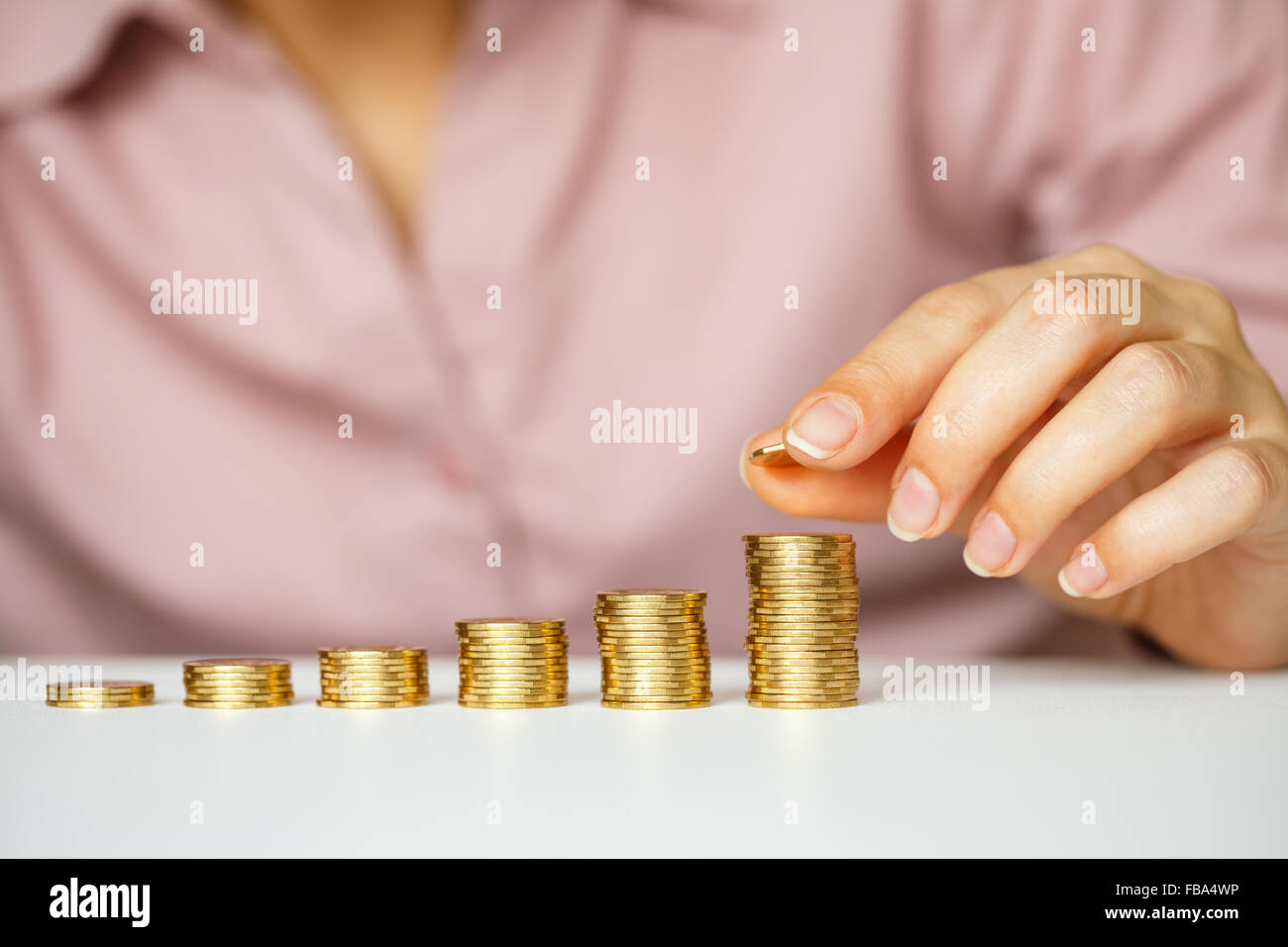 Savings, female hand stacking gold coins into increasing columns Stock ...