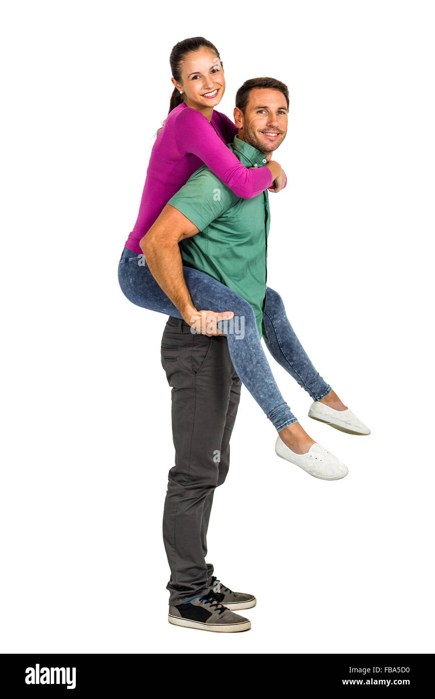 Smiling couple giving piggy back Stock Photo - Alamy