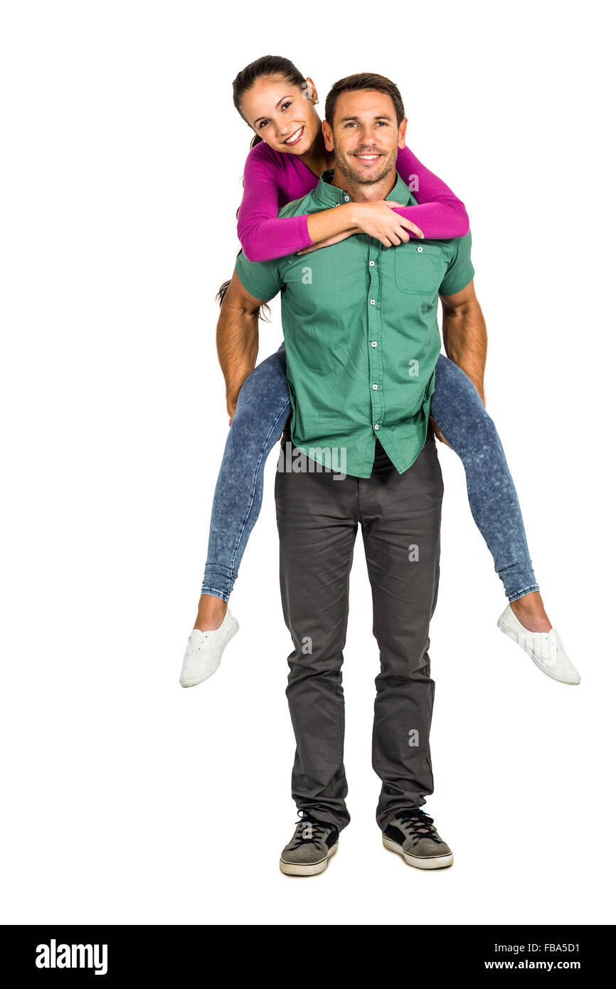 Happy couple giving piggy back Stock Photo - Alamy