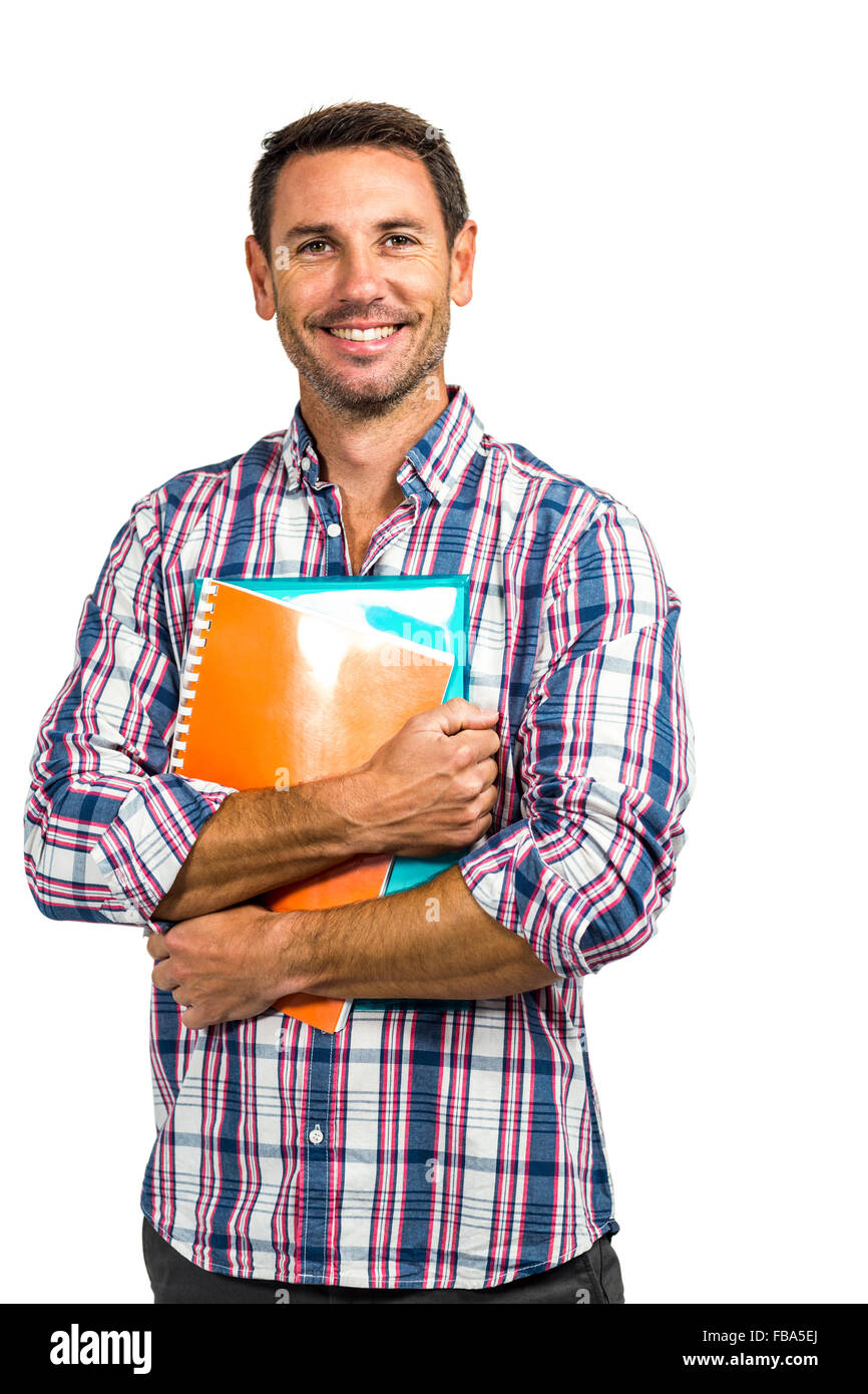 Smiling man standing holding notepads Stock Photo - Alamy