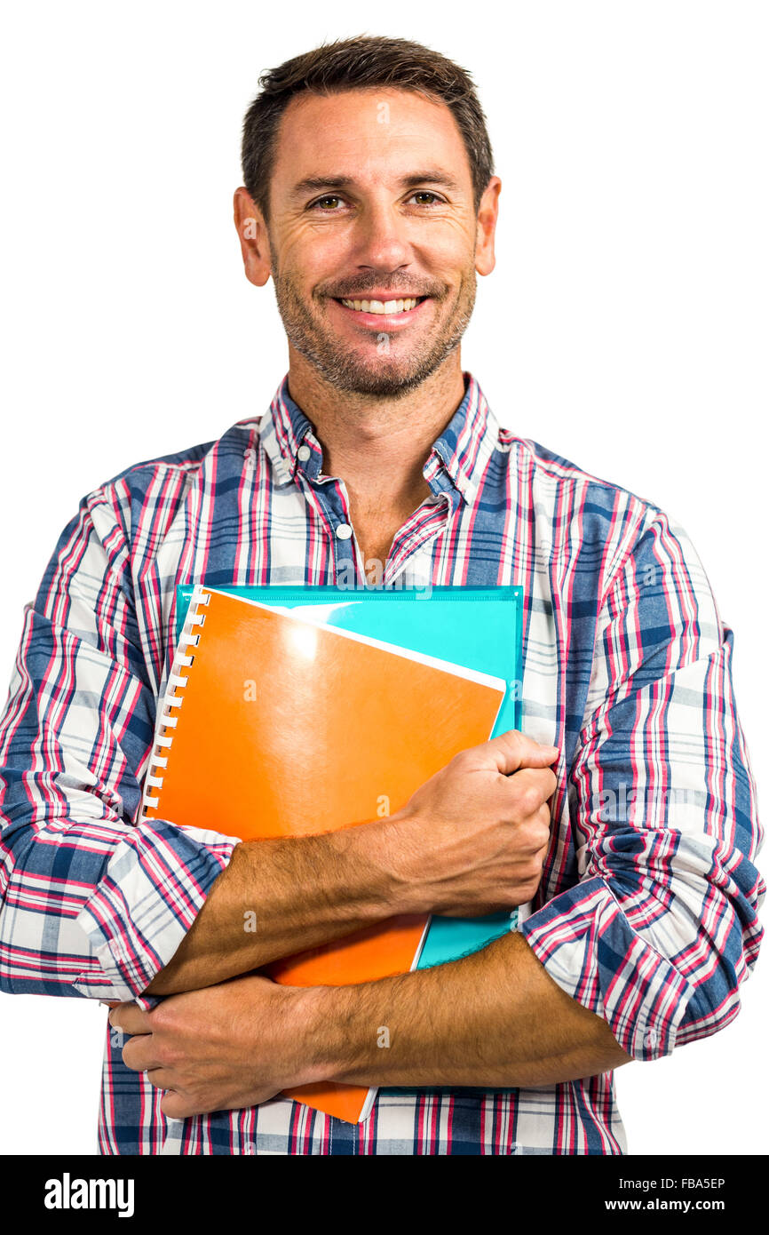 Smiling man standing holding notepads Stock Photo - Alamy