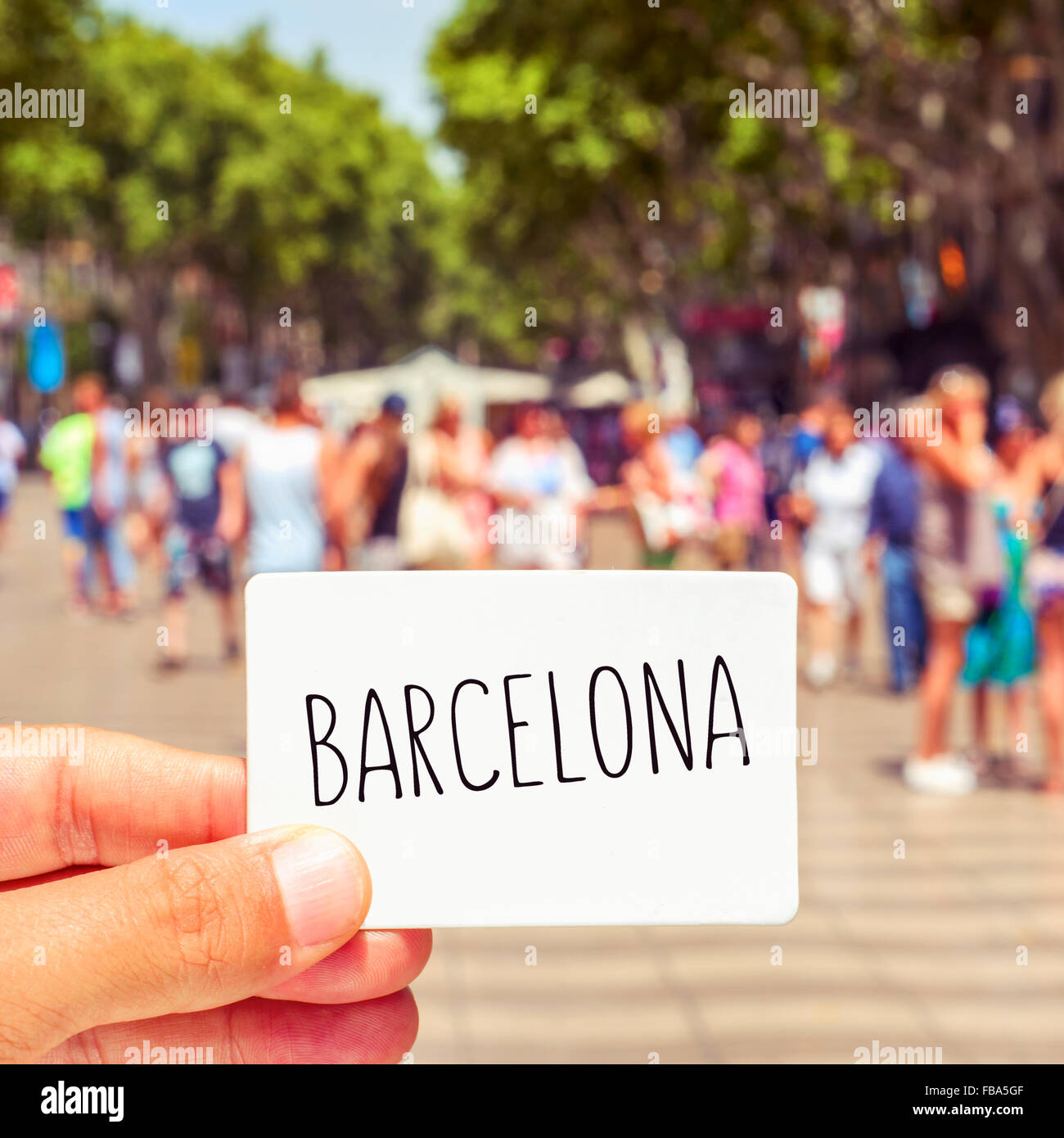 closeup of the hand of a young man showing a signboard with the word ...