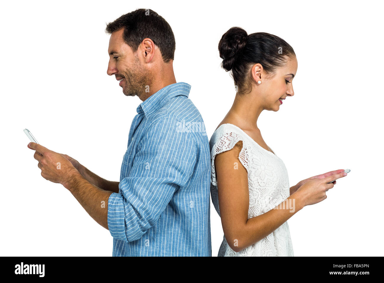 Couple standing back to back using smartphones Stock Photo - Alamy
