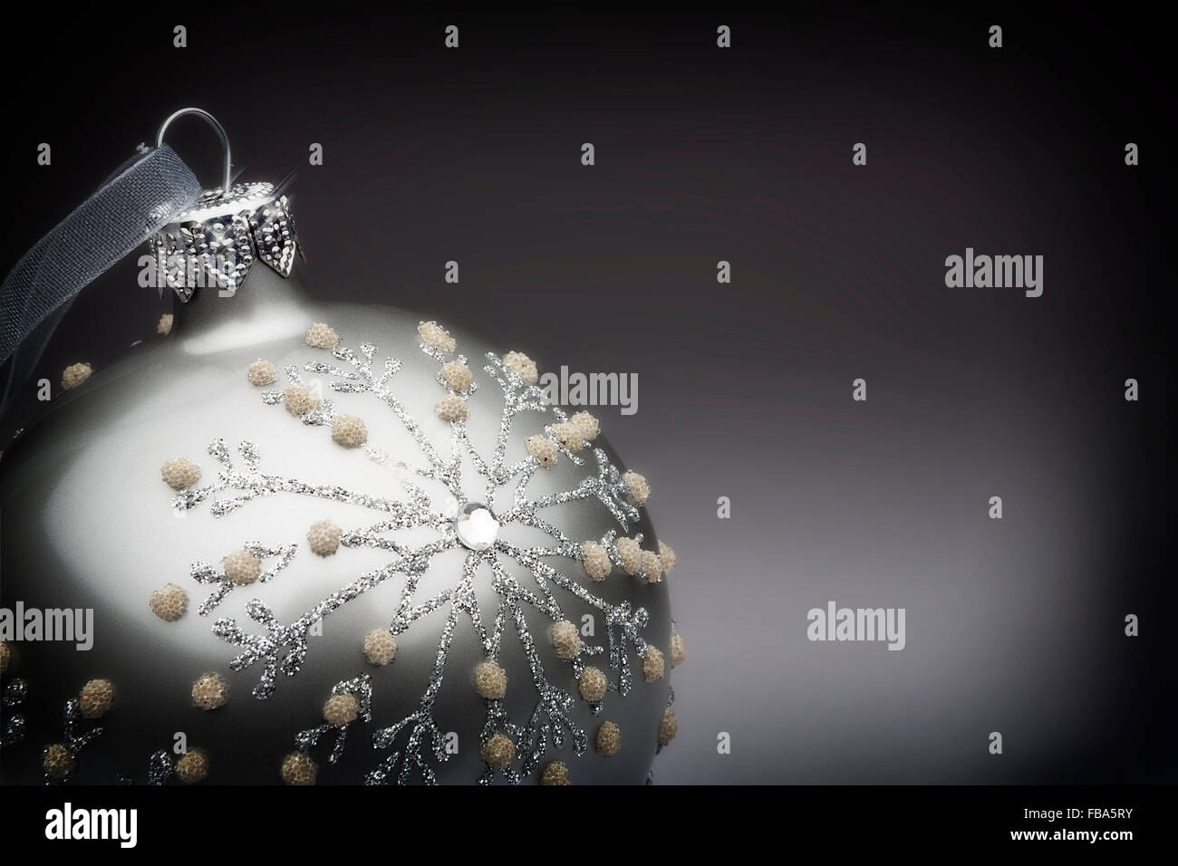 Silver tree decoration isolated on a grey to black background with copy ...