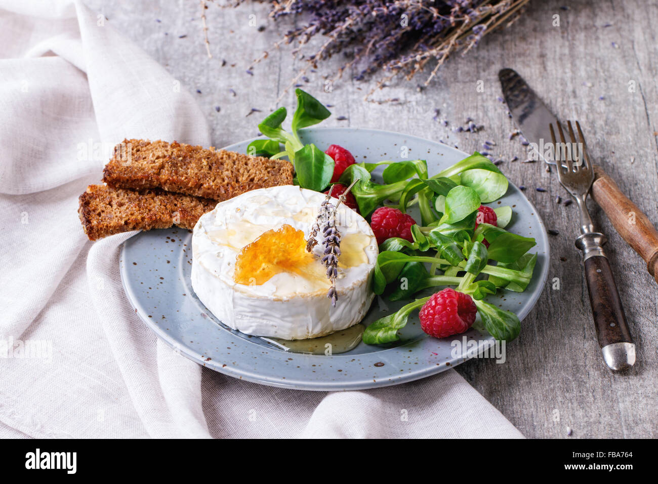 Goat cheese with honey and raspberries Stock Photo - Alamy