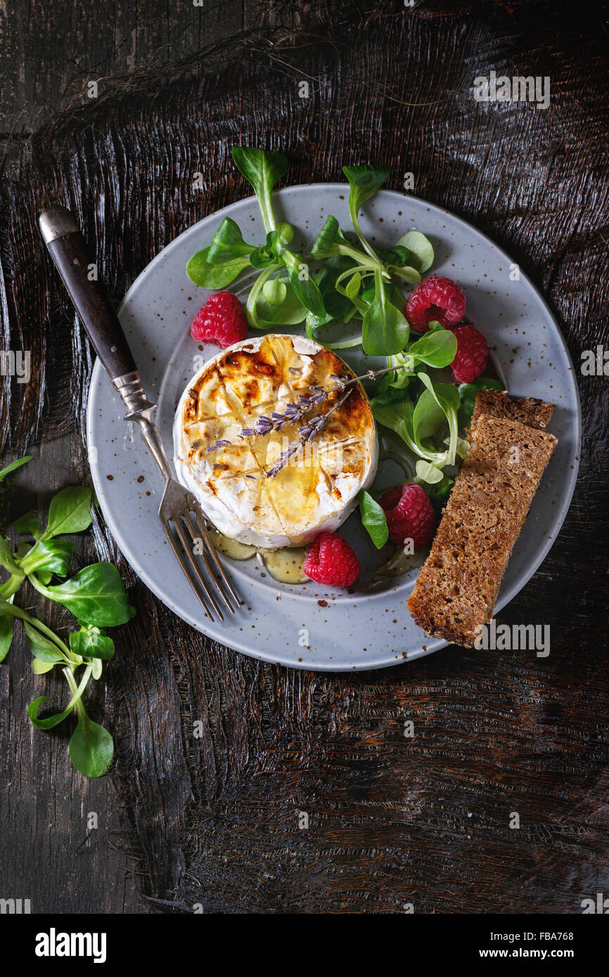 Baked Goat cheese with honey and raspberries Stock Photo - Alamy