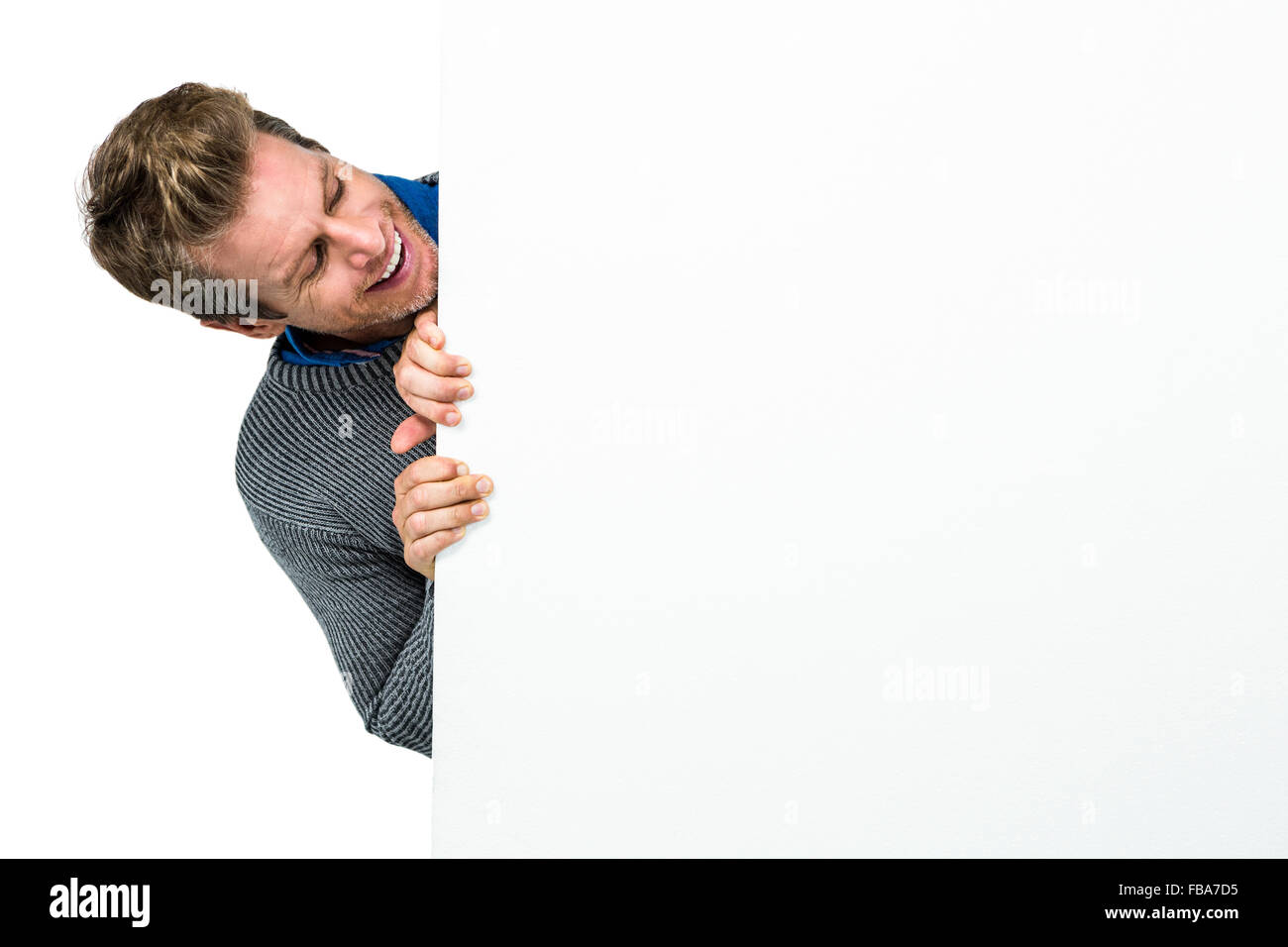 Smiling man behind board Stock Photo - Alamy
