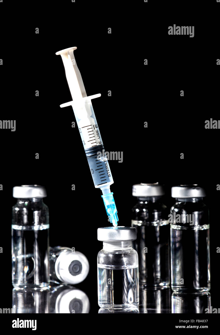 Glass Medicine Vials and Syringe on black background Stock Photo - Alamy
