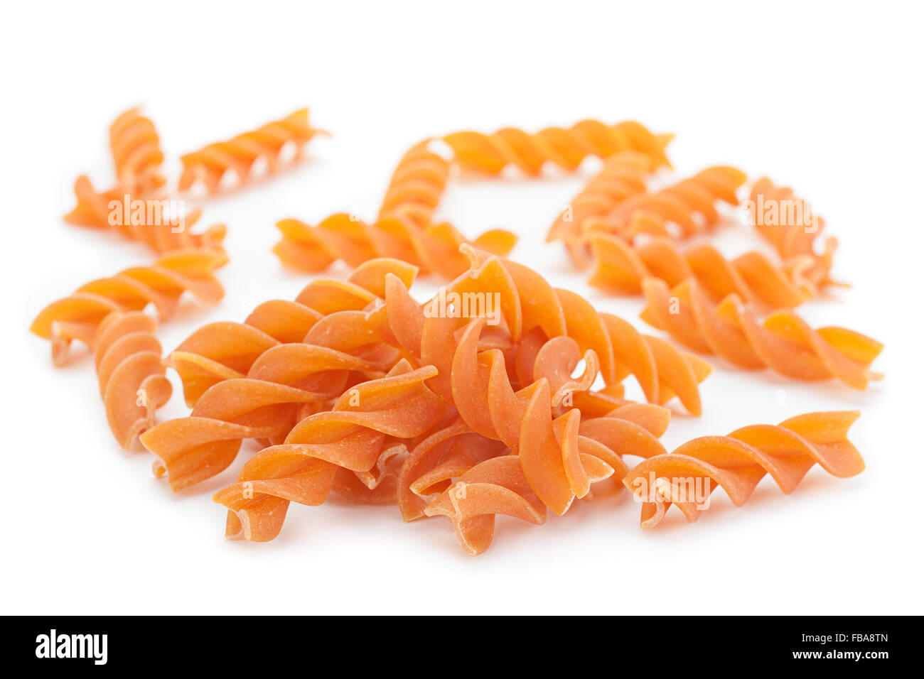 Orange swirl dry pasta closeup isolated on white background Stock Photo ...