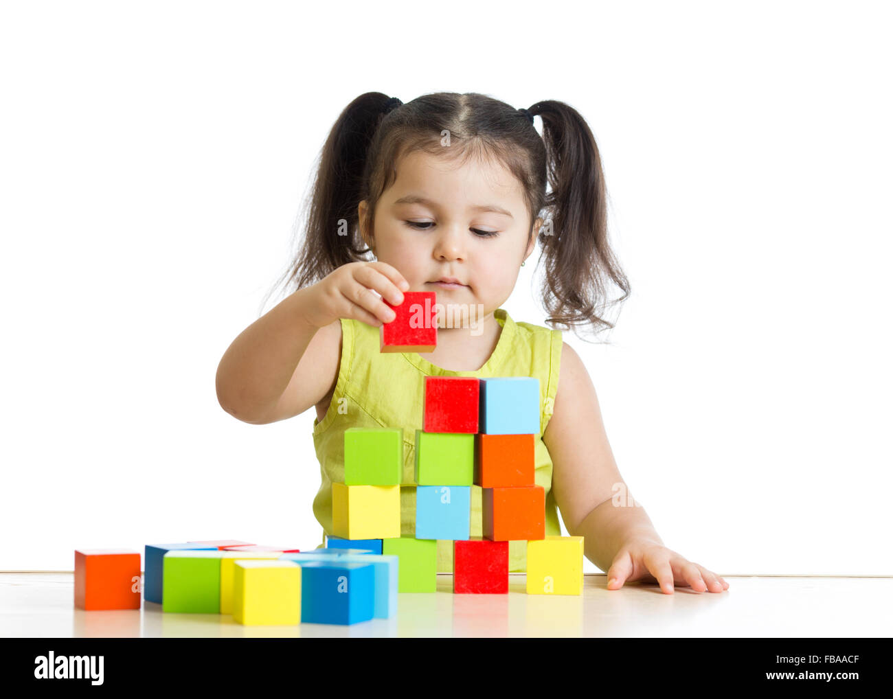 Beautiful child plays building a castle with cubes Stock Photo - Alamy