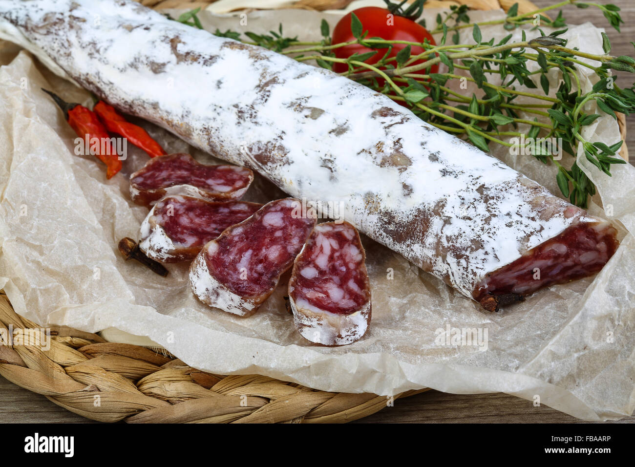 Traditional Spanish sausages- fuet with thyme leaves on the wood ...