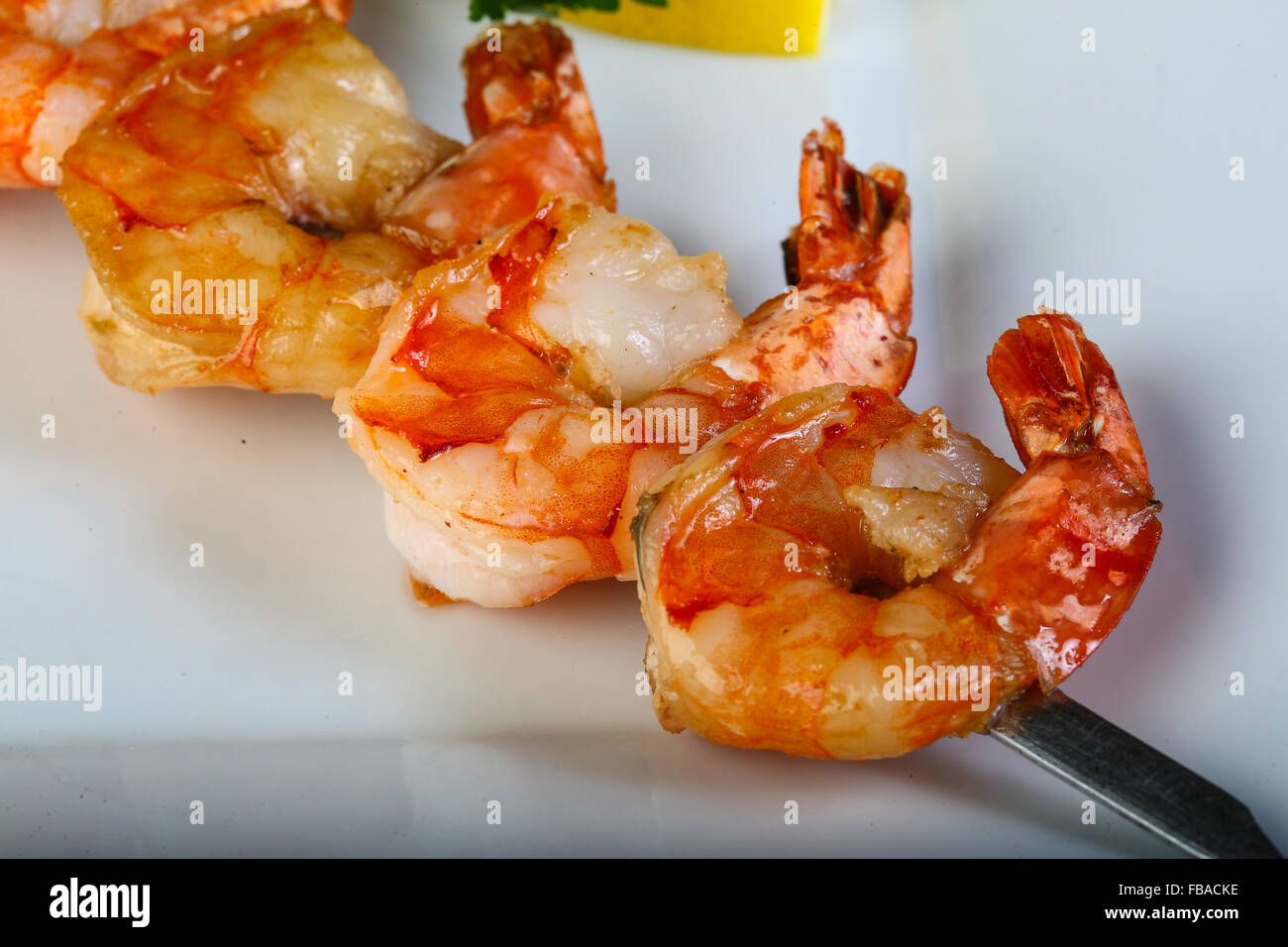 Tiger prawn skewer served sliced lemon and parsley Stock Photo - Alamy