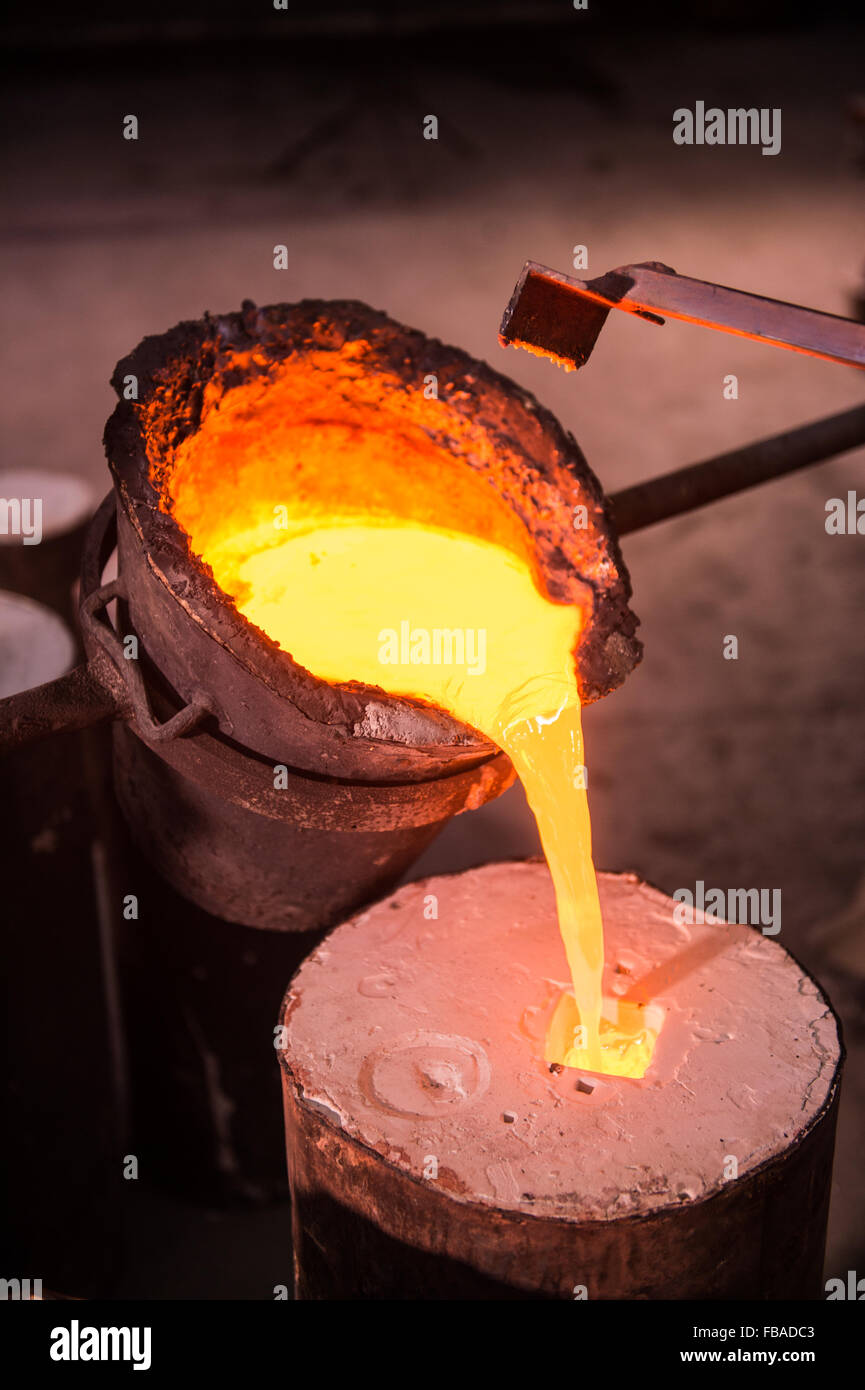 Foundry worker pouring hot metal into cast Stock Photo - Alamy