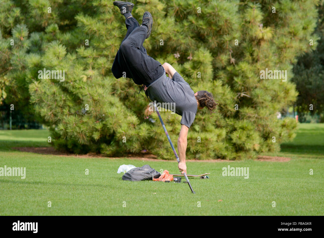 Fire Performer practicing moves with pole in daytime in park in Bedford ...
