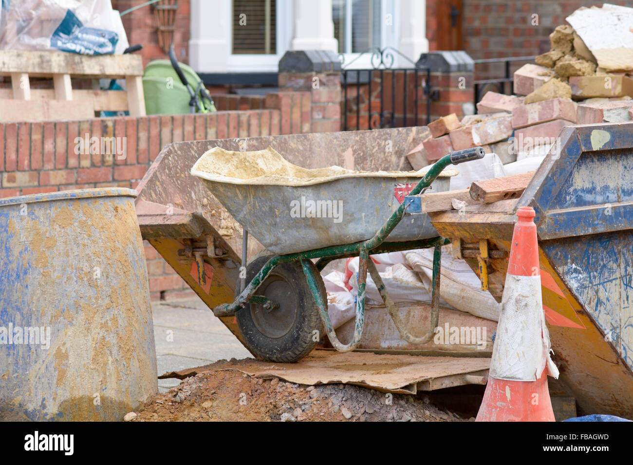 Wheelbarrow in skip on construction site Stock Photo - Alamy