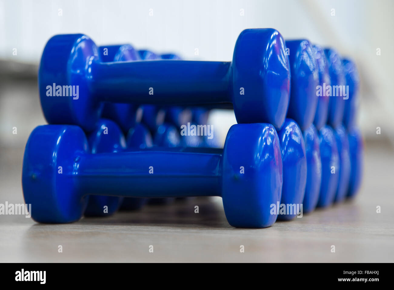 Stack of blue dumbbells on the floor in sports hall Stock Photo - Alamy