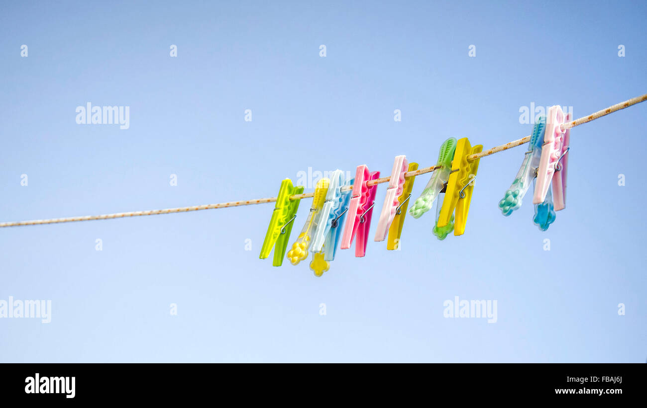 Colorful clothes pegs on a rope Stock Photo - Alamy