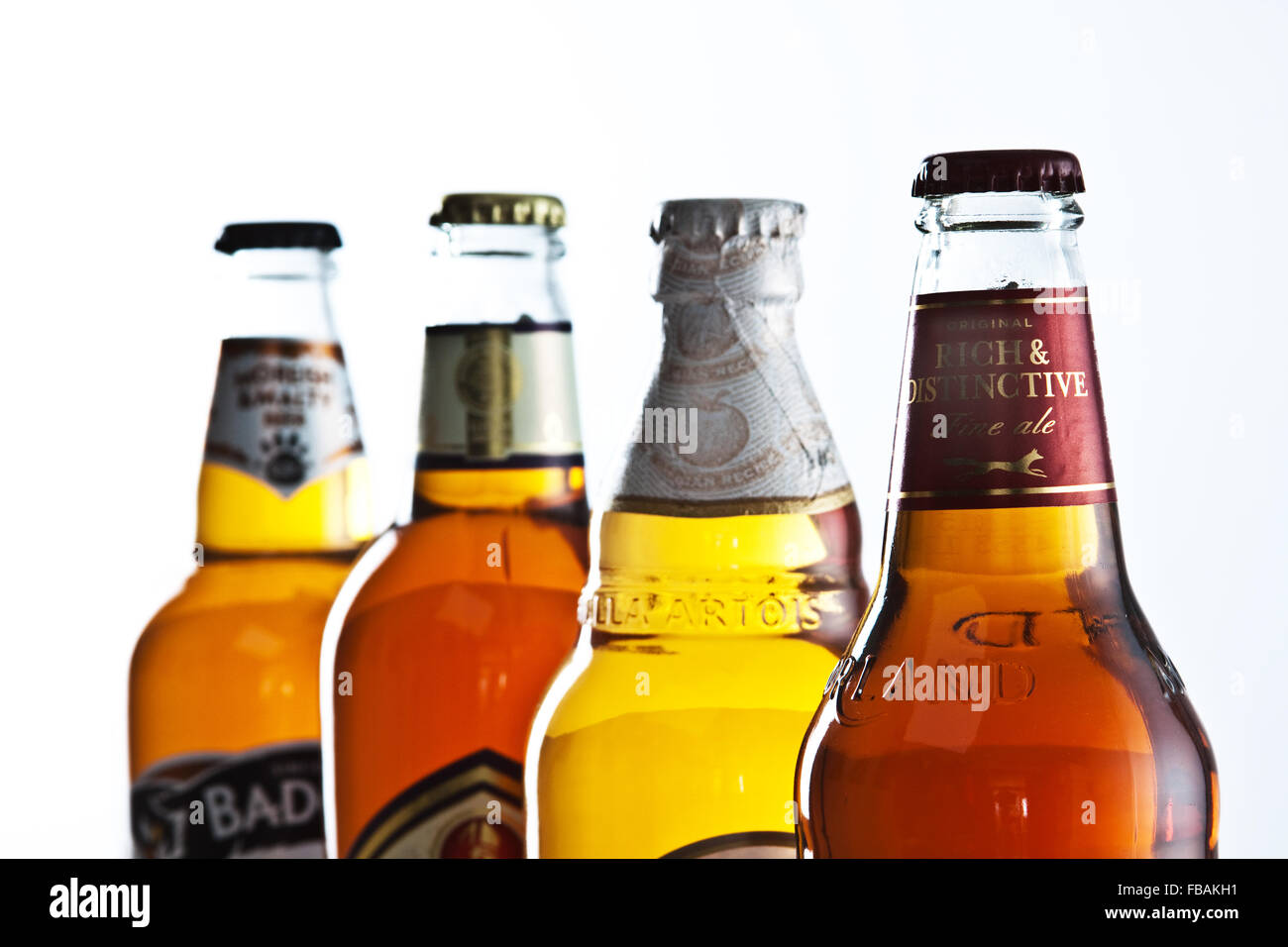 Four colourful beer and cider bottles arranged to show depth of field ...