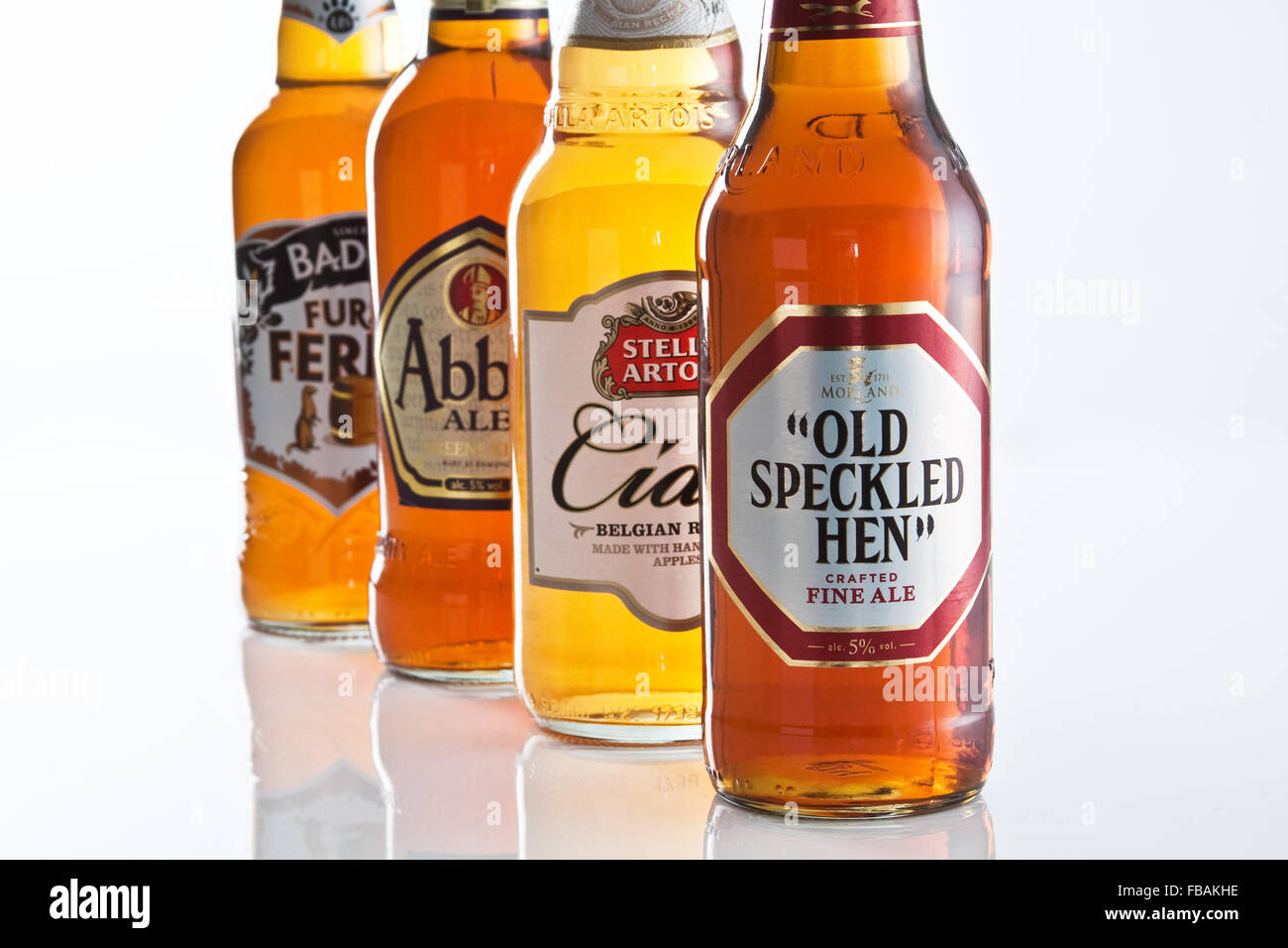 Four colourful beer and cider bottles arranged to show depth of field ...