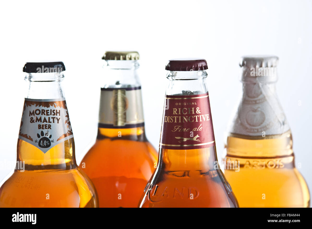 Four colourful beer bottles arranged to show depth of field and ...